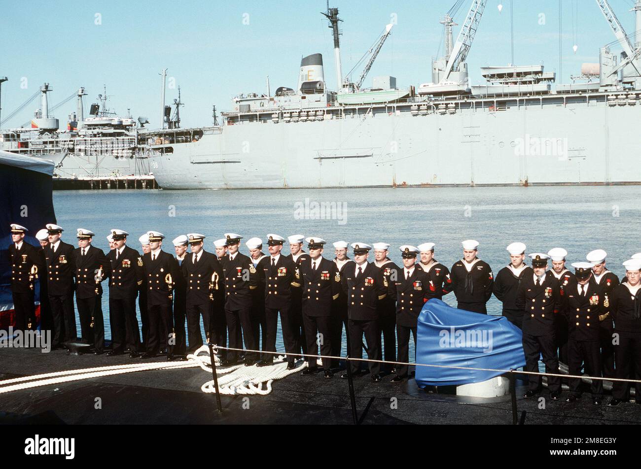 Crew members stand in formation aboard the nuclear-powered attack ...