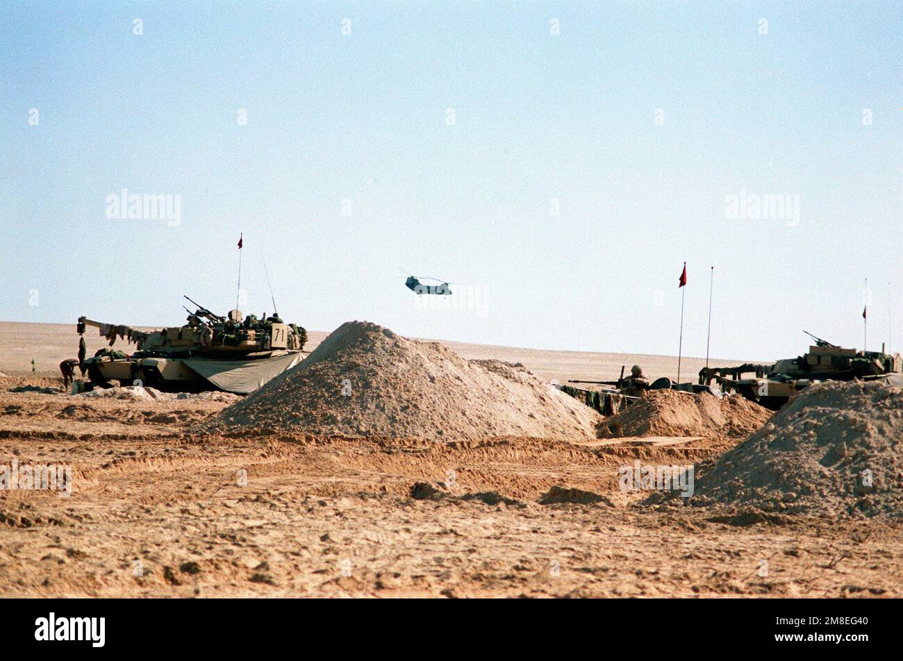 A CH-46 Sea Knight helicopter flies over Tiger Brigade M-1A1 Abrams ...