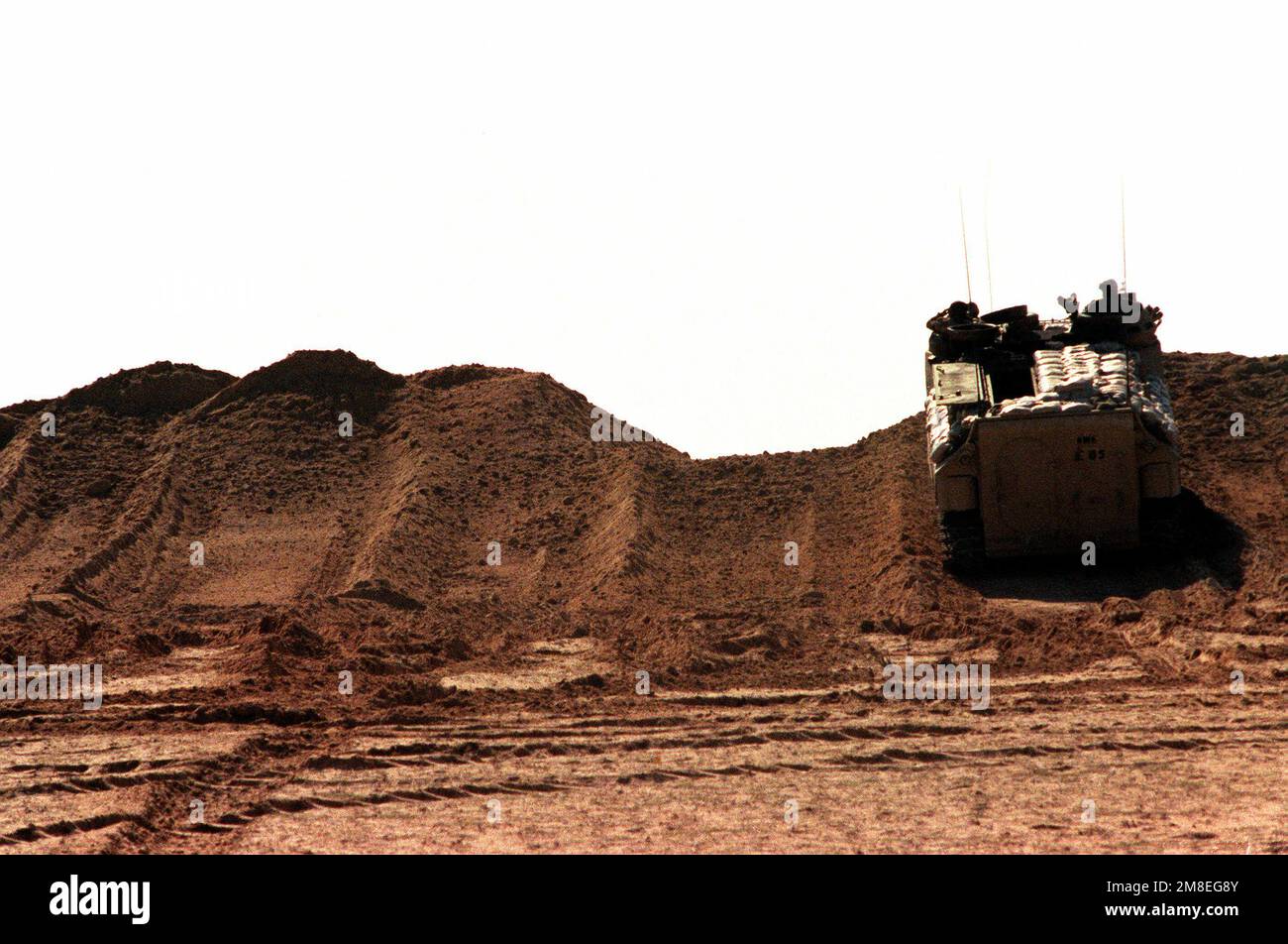 An AAVP-7A1 assault amphibian vehicle passes through a hole blasted in ...