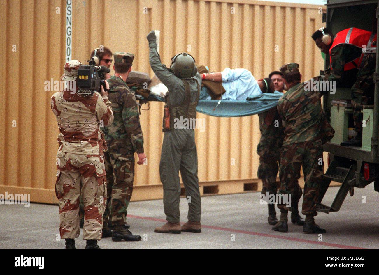 A Navy cameraman videotapes a wounded Marine as he is lifted into the back of an ambulance at ...