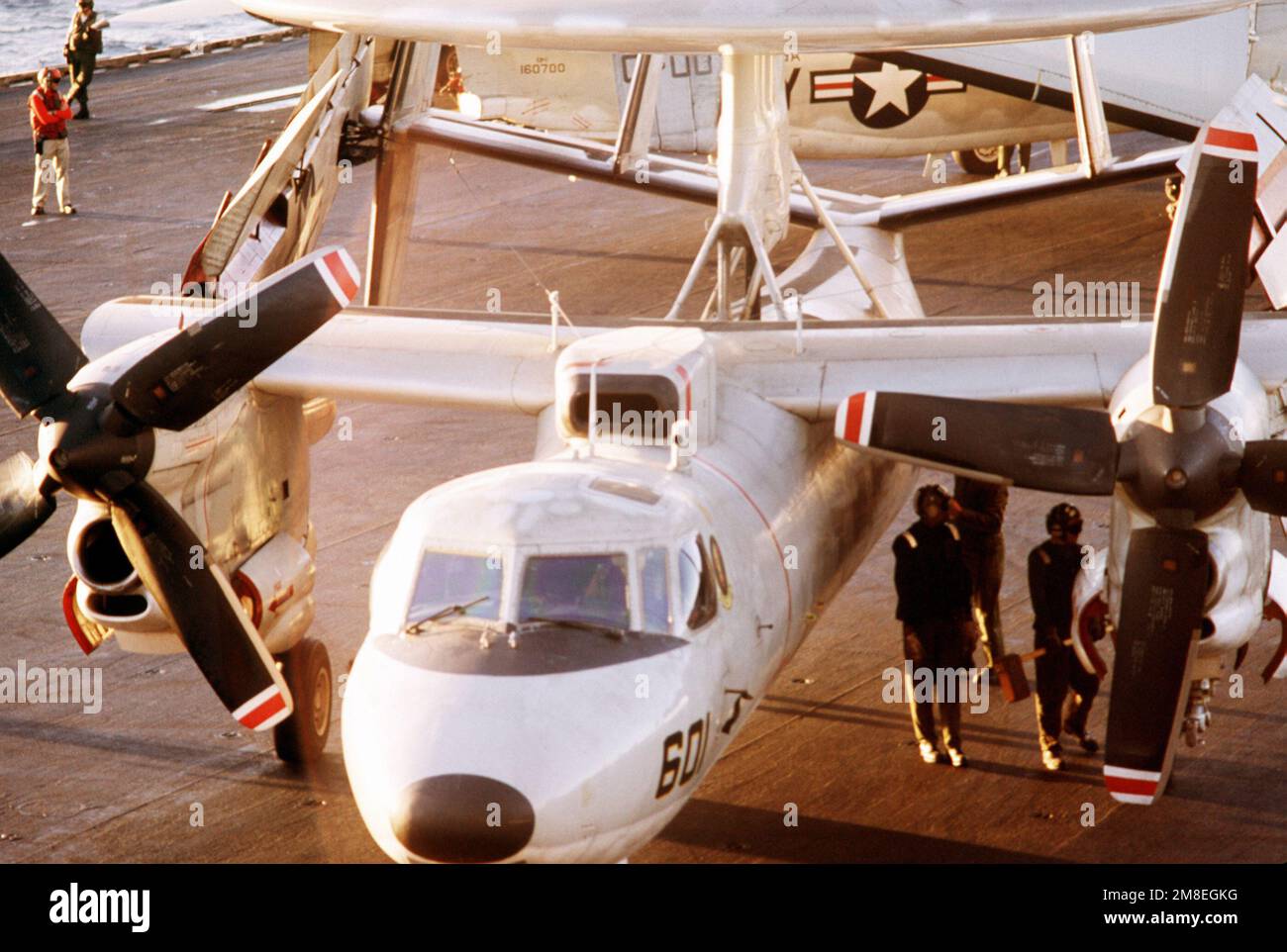 Flight deck crewmen prepare to move an Airborne Early Warning Squadron ...