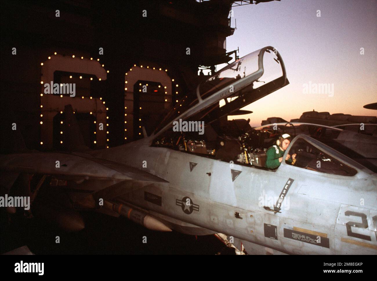 A flight deck crewmen works in the cockpit of a Fighter Squadron 103 (VF-103) F-14A Plus Tomcat ...