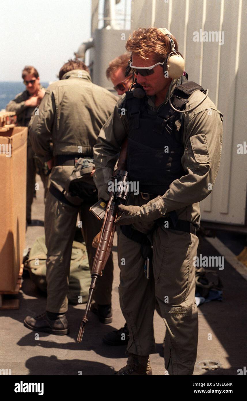 A member of Sea-Air-Land (SEAL) Team 8 checks his optical sight ...