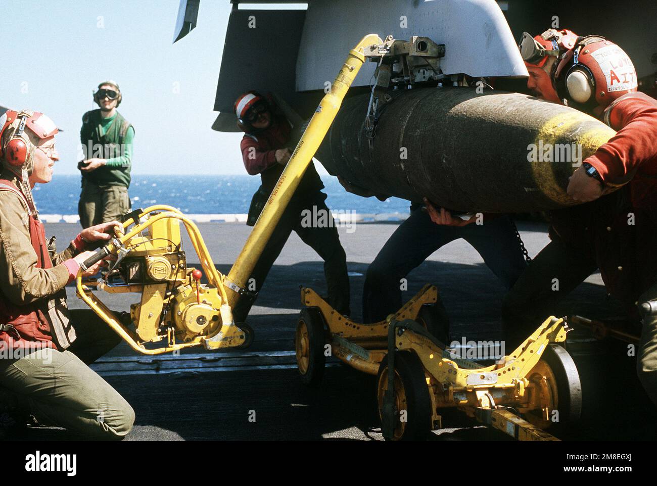 Ordnancemen use an HLU-196 bomb hoist to load a Mark 84 2,000-pound ...
