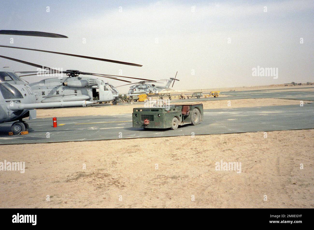 An MD-3 tow tractor sits in front of a CH-53E Super Stallion helicopter ...