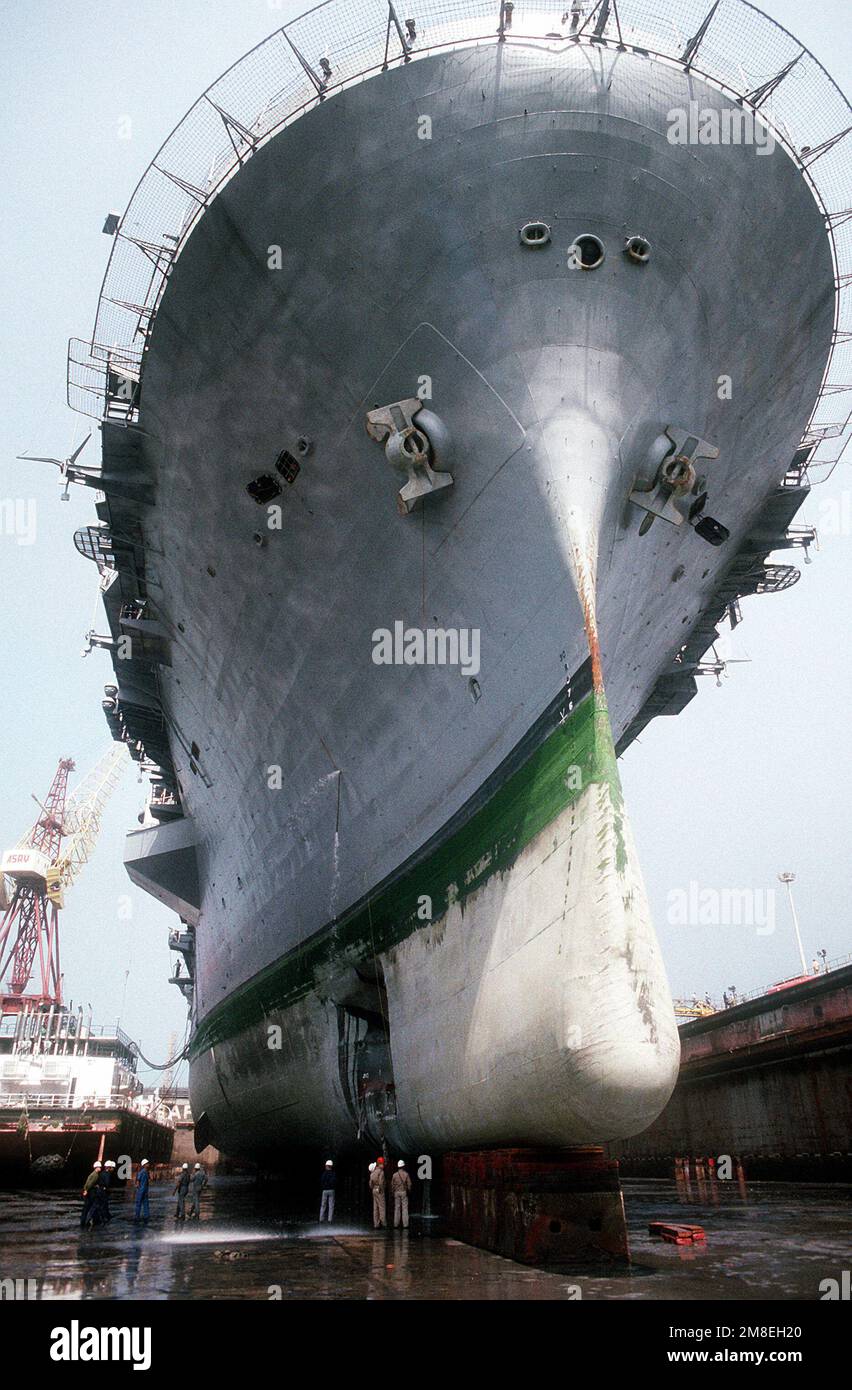 Navy personnel inspect damage to the hull of the amphibious assault ...