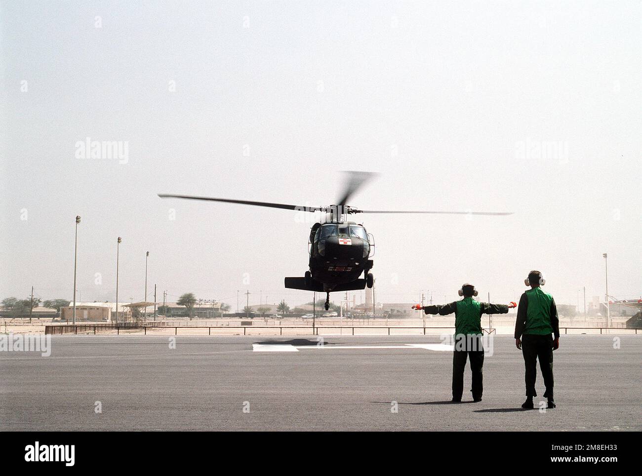 A landing signal enlisted man (LSE) guides an Army UH-60A Black Hawk ...