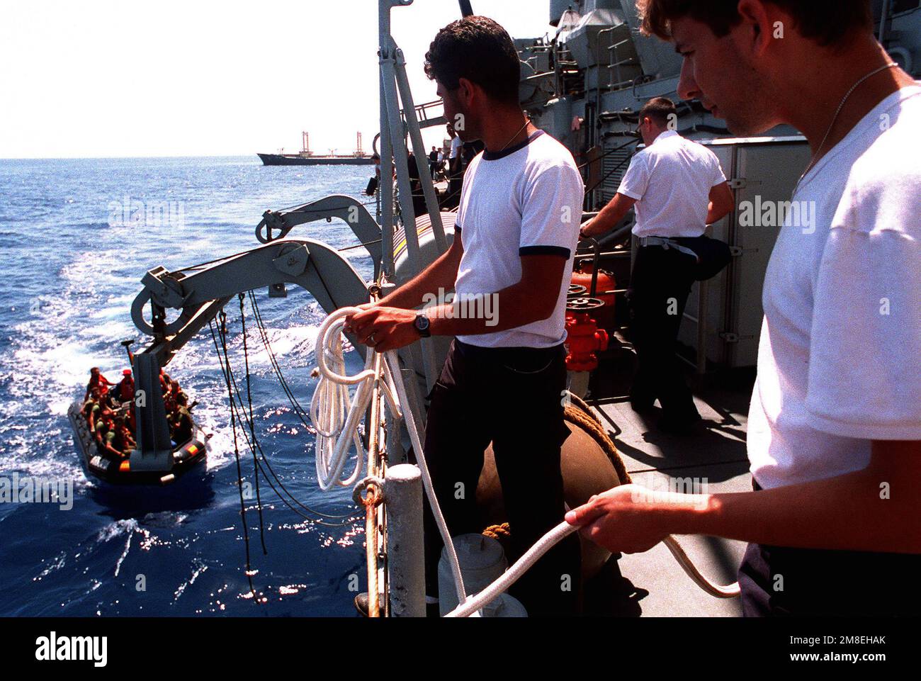 A sailor aboard the Spanish frigate Vencedora (F-36) stands by to toss ...