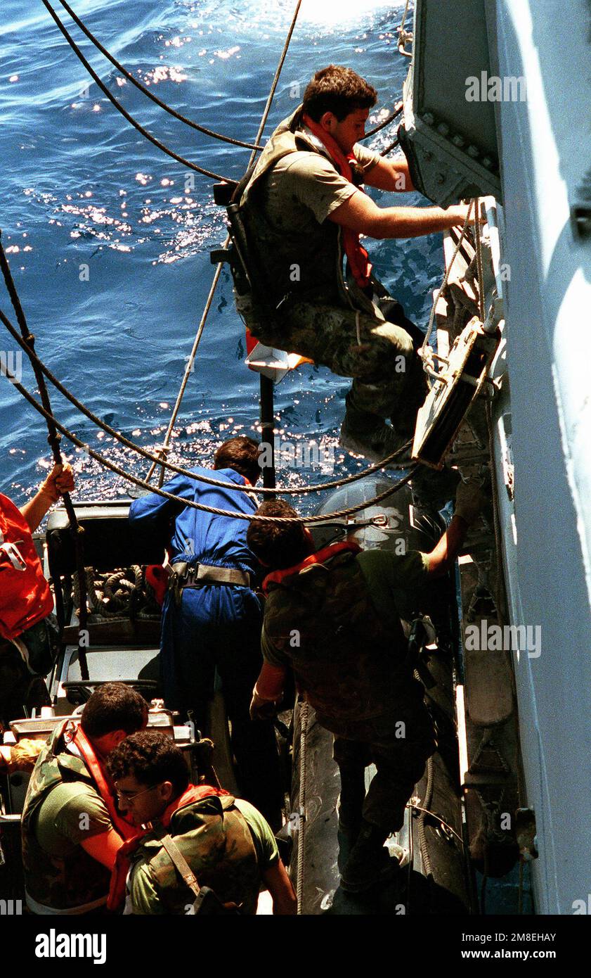 Members of the ship's boarding party climb aboard the Spanish frigate ...
