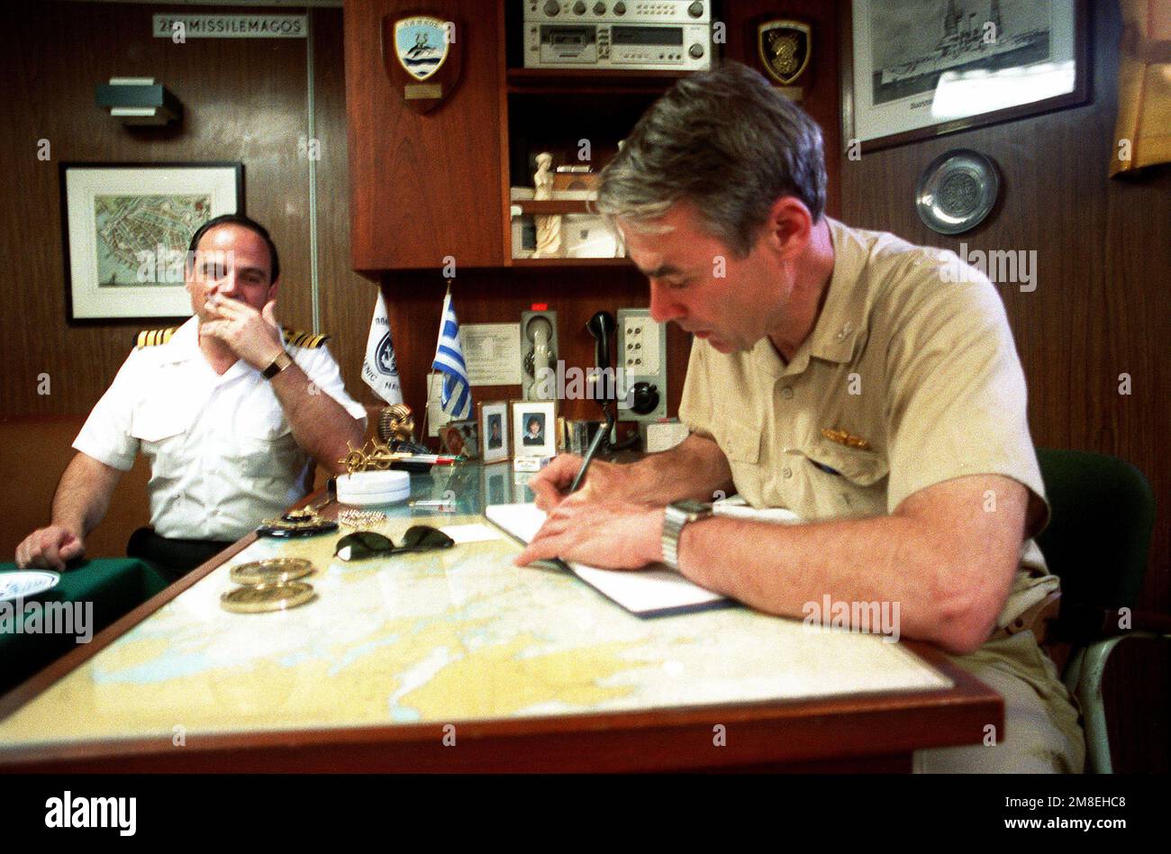 CAPT. Douglas C. Bauer, a U.S. Navy historian, signs the guest book ...