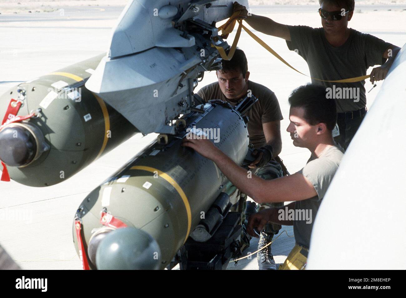 Members of the 4th Weapons Squadron load SUU-65/B tactical munition ...