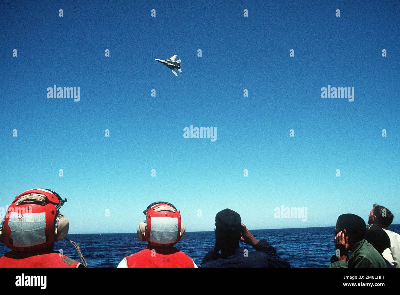 Crew members and U.S. Coast Guardsmen aboard the guided missile ...