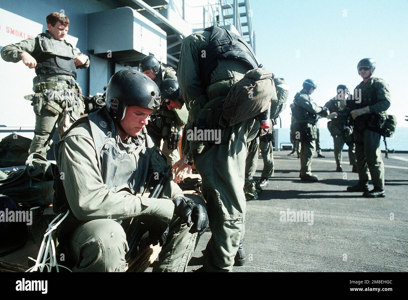 Members of Sea-Air-Land (SEAL) Team 8 gather up their gear as they ...