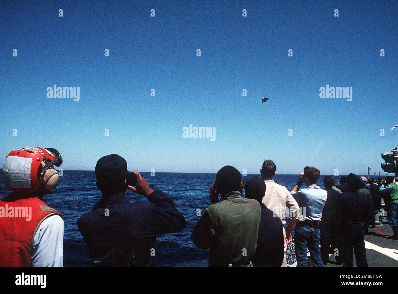 Crew members and U.S. Coast Guardsmen aboard the guided missile ...