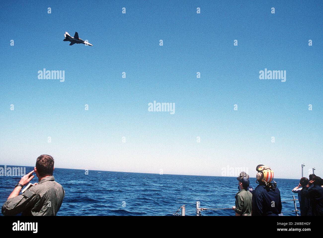 Crew members and U.S. Coast Guardsmen aboard the guided missile ...