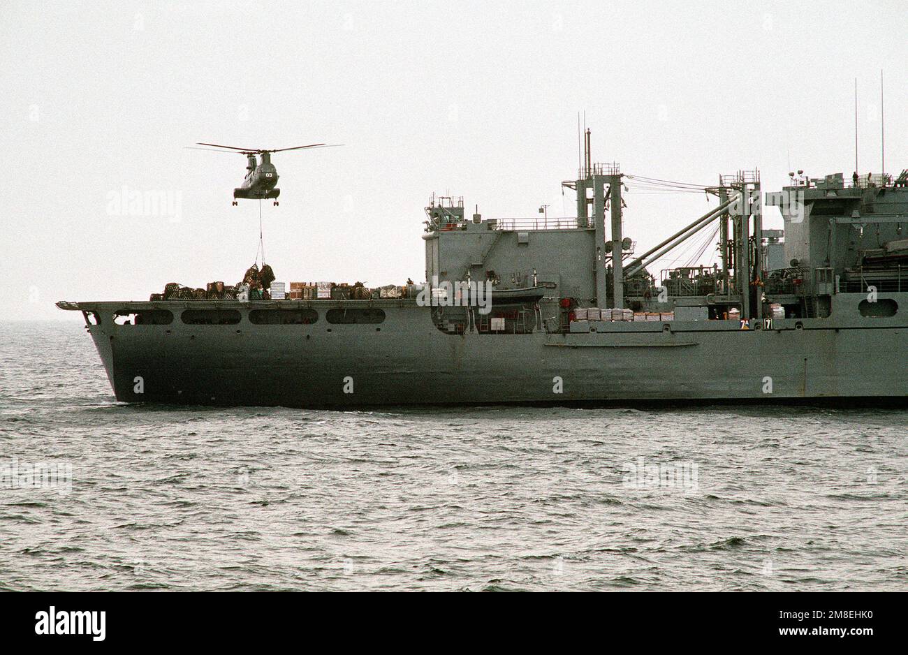 A HH-46A Sea Knight helicopter lifts a load of cargo from the flight ...