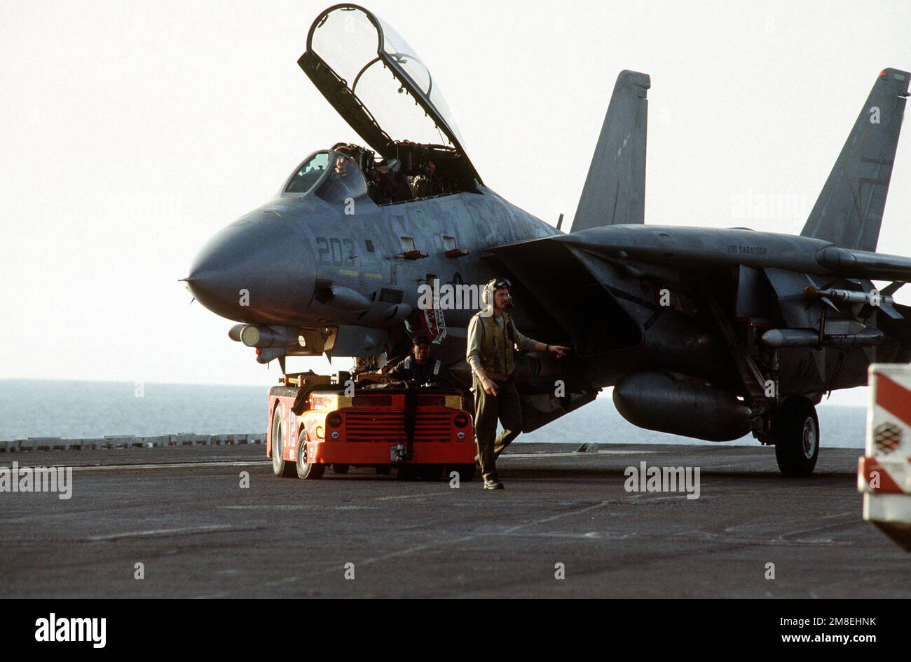An aircraft handling officer directs the driver of an MD-3A tow tractor as they move a Fighter ...