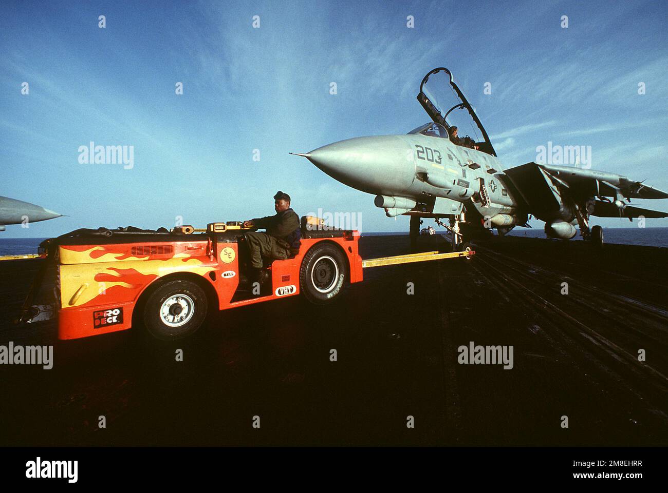 AIRMAN Chuck Spias sits behind the wheel of an MD-3A tow tractor as he waits to move a Fighter ...