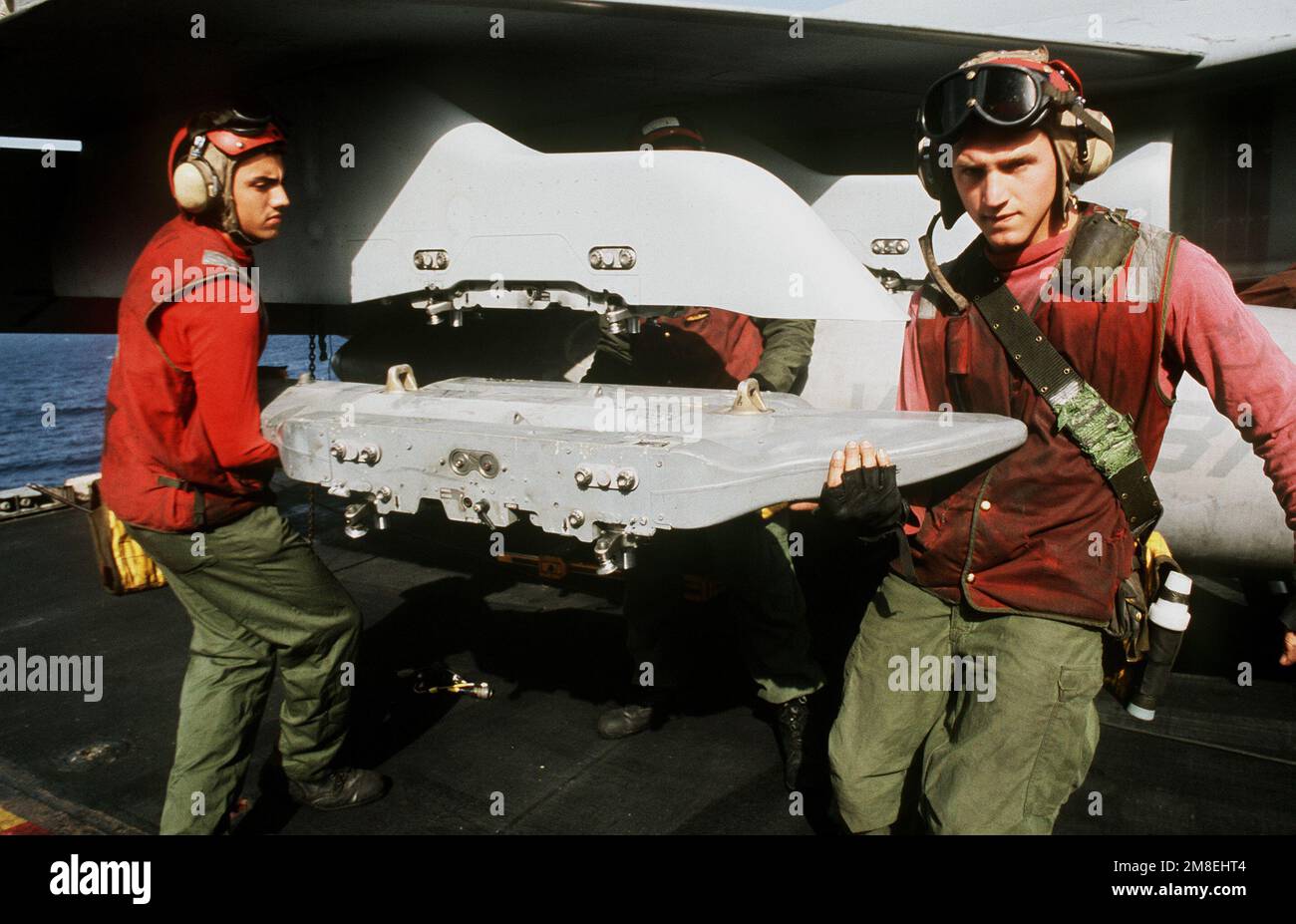 Aviation ordnancemen from Strike Fighter Squadron 81 (VFA-81) remove a ...