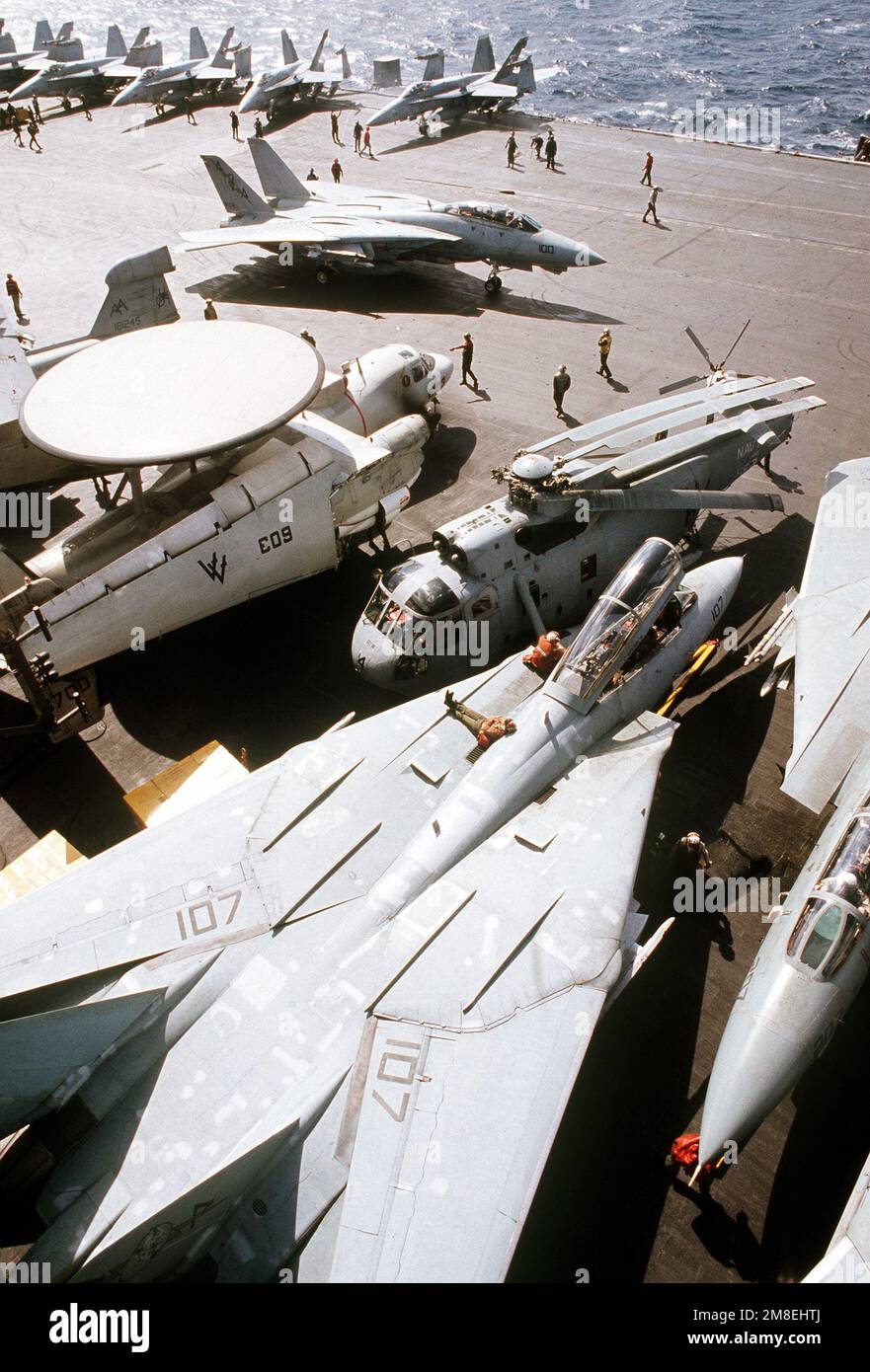 A Fighter Squadron 74 (VF-74) F-14A Tomcat aircraft taxis past a Carrier Airborne Early Warning ...