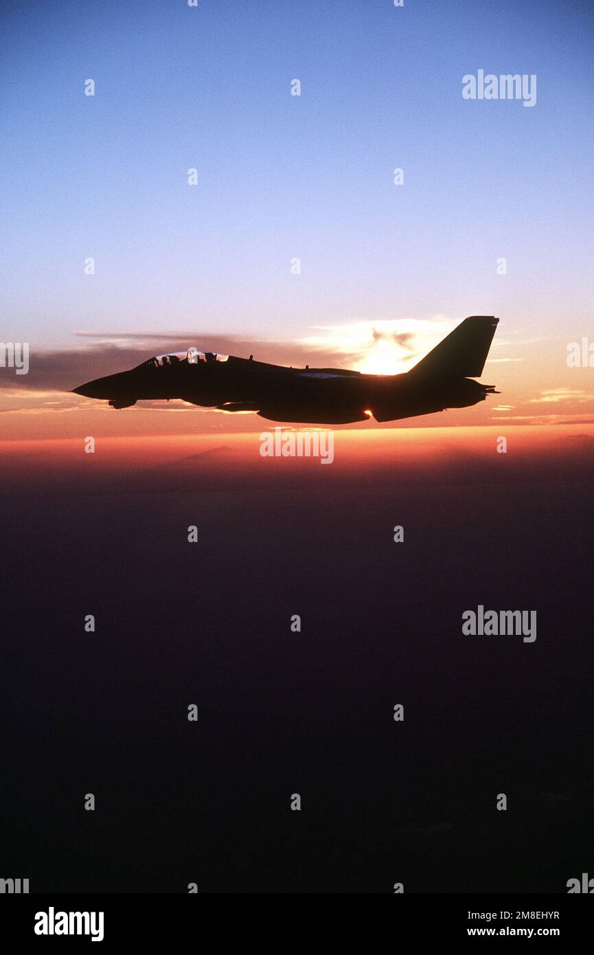 A Fighter Squadron 32 (VF-32) F-14A Tomcat aircraft is silhouetted ...
