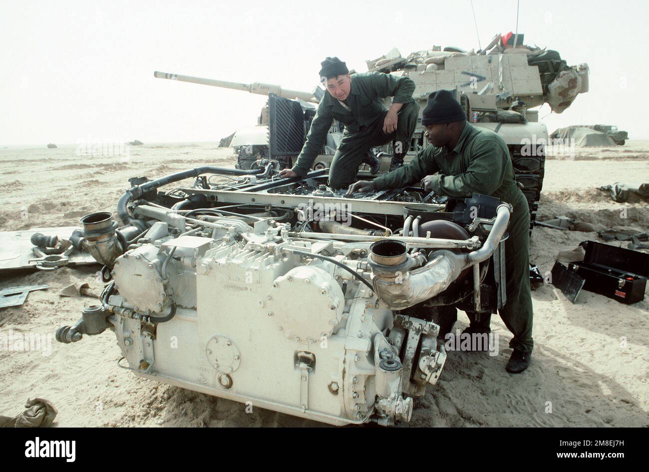 Two Marines perform maintenance on the power pack from an M-60A1 tank ...
