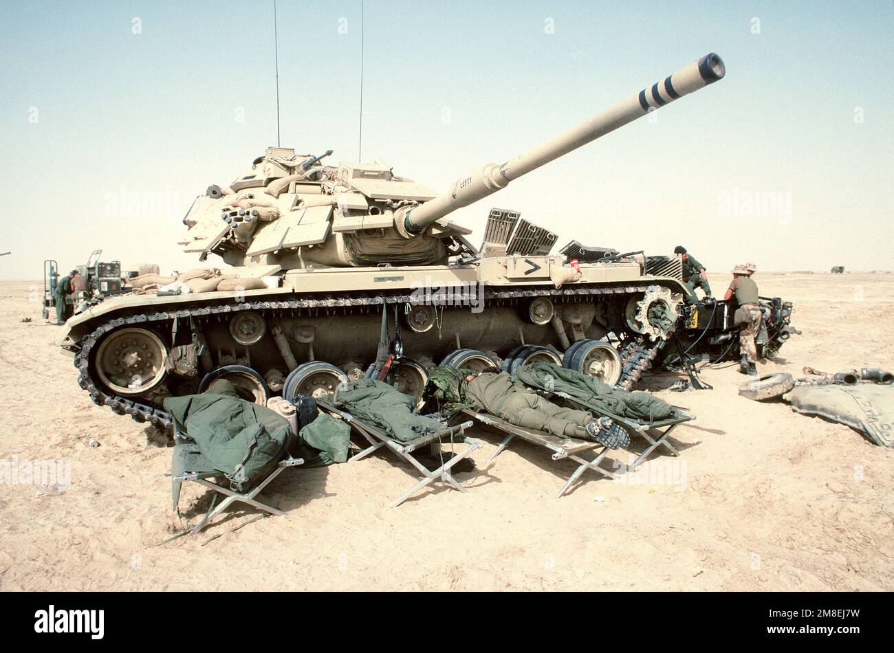 Two Marine M-60A1 tank crewmen stretch out on their cots as other ...