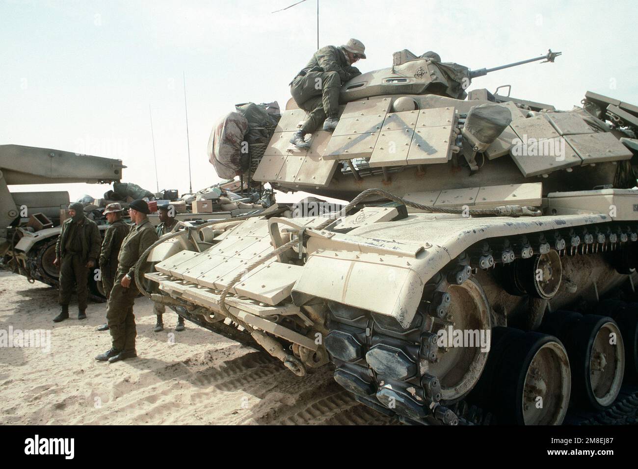 A Marine looks in the commander's cupola atop an M-60A1 tank parked in ...