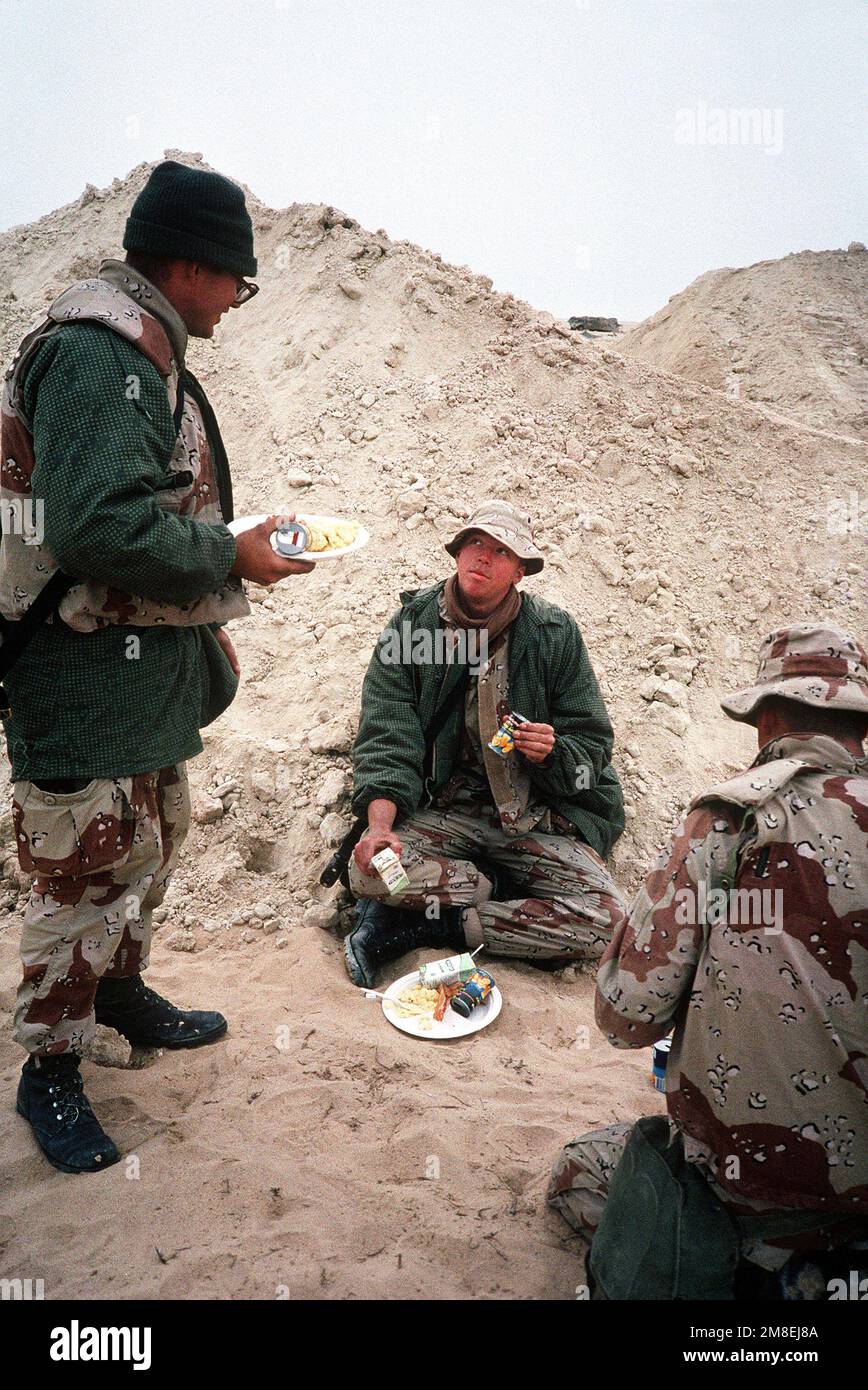 Marines have breakfast beside a berm at a camp in northern Saudi Arabia ...