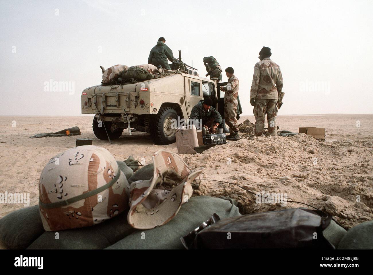 A combat photographer takes a shot of a Marine kneeling behind the M-2 ...