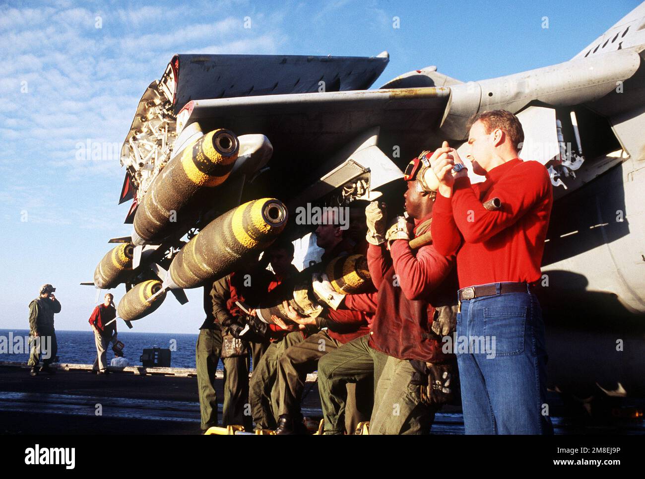 Aviation ordnancemen from Attack Squadron 75 (VA-75) hoist another Mark ...