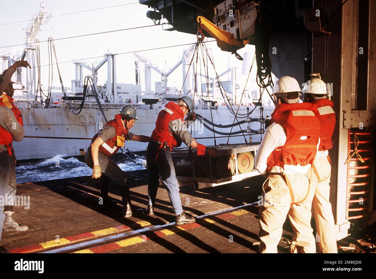 Two sailors aboard the aircraft carrier USS SARATOGA (CV-60) steady a ...