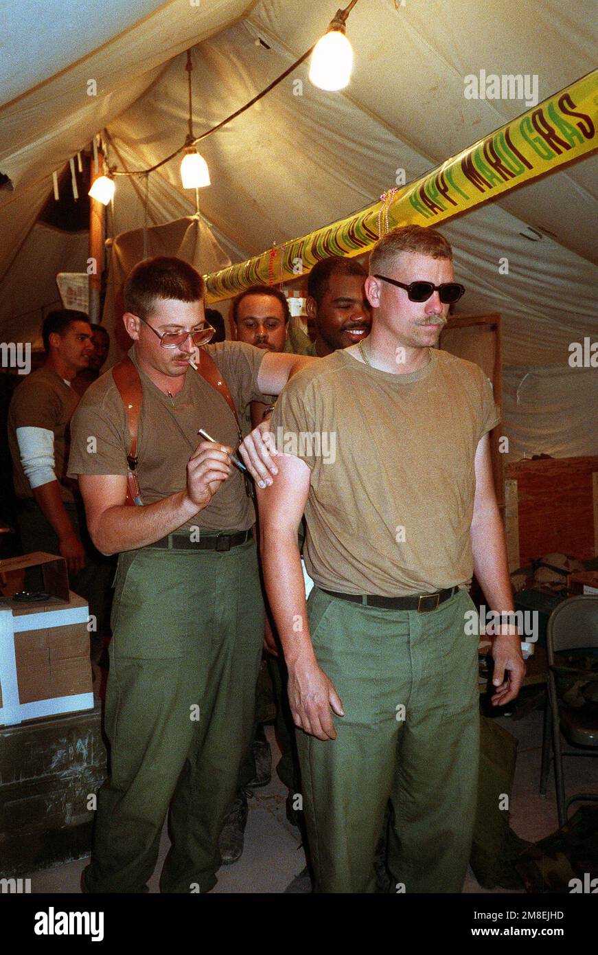 A Seabee from Naval Mobile Construction Battalion 5 (NMCB-5) receives ...