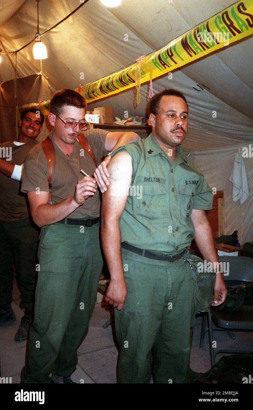 A Seabee from Naval Mobile Construction Battalion 5 (NMCB-5) receives ...