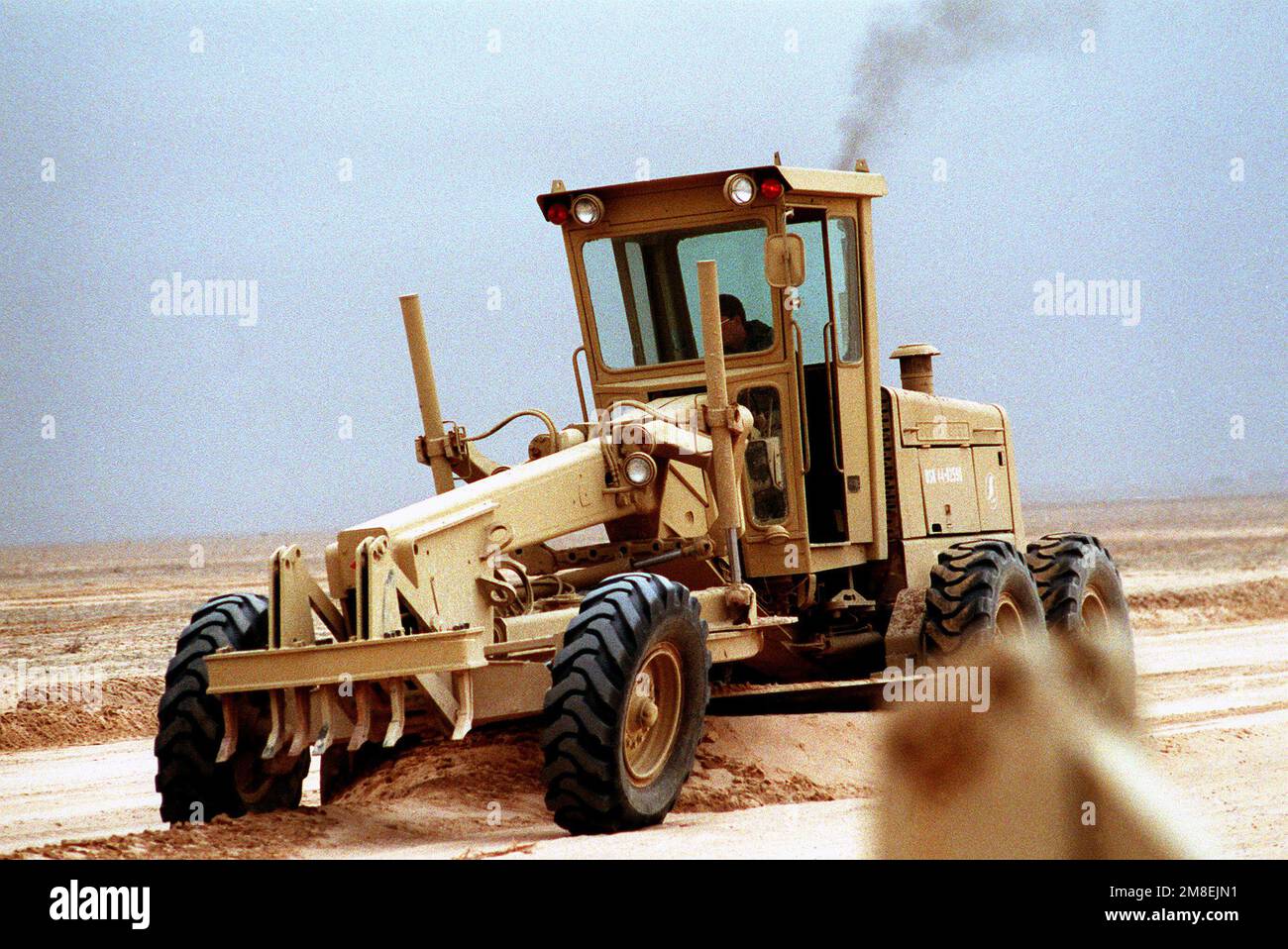 A Seabee from Naval Mobile Construction Battalion 5 (NMCB-5) drives a ...