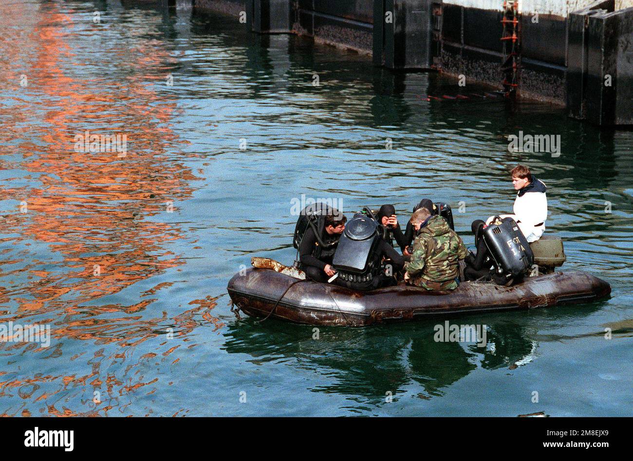 A team of explosive ordnance disposal (EOD) divers sets out to search ...