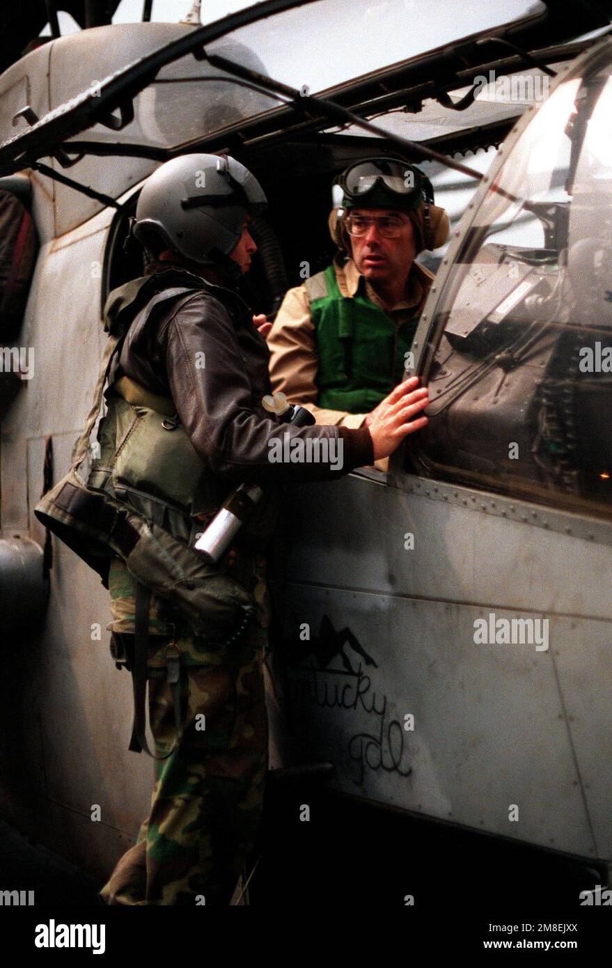 The pilot of a Marine Corps AH-1 Sea Cobra helicopter talks to a ...