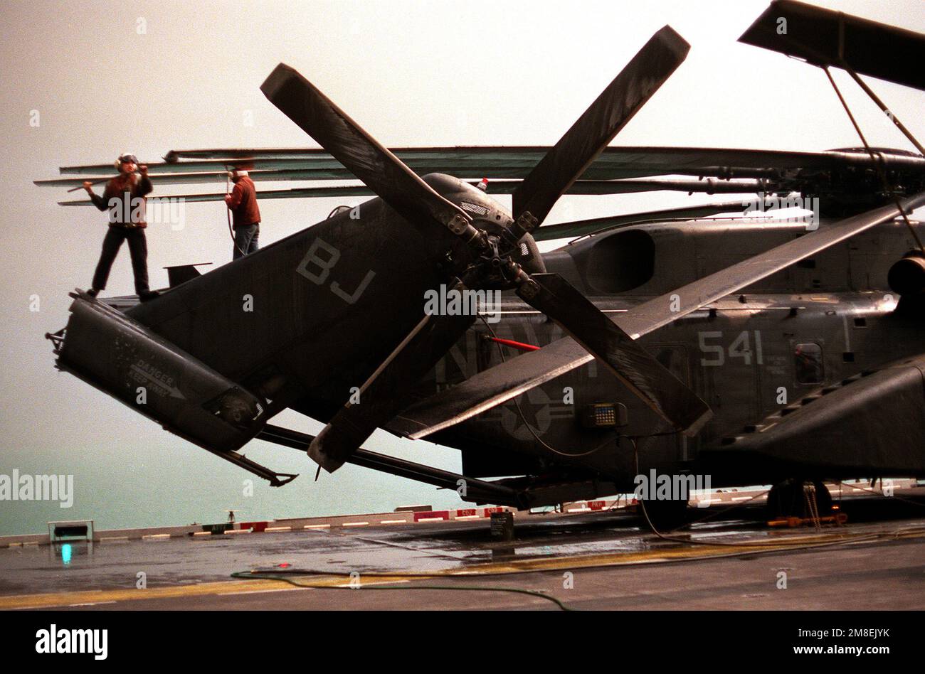 Maintenance crewmen scrub down the rotor blades of a Helicopter Mine ...