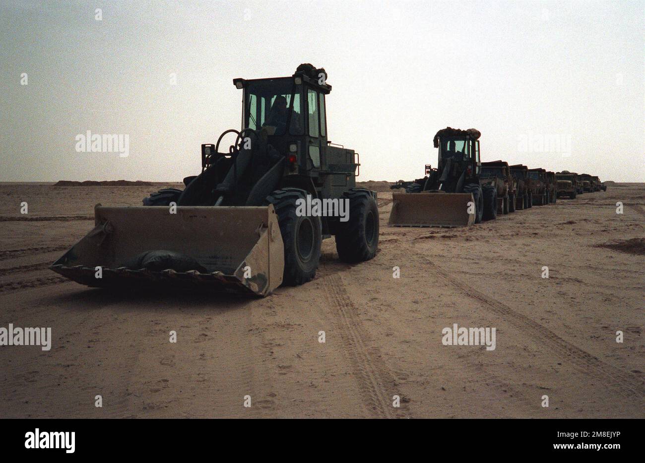 Led by a pair of loaders, a convoy of vehicles from Naval Mobile ...