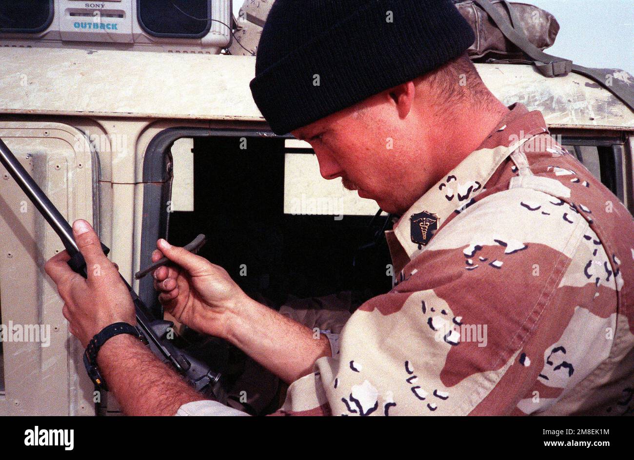 A Navy corpsman assigned to a Marine unit cleans his M-16A2 rifle after ...