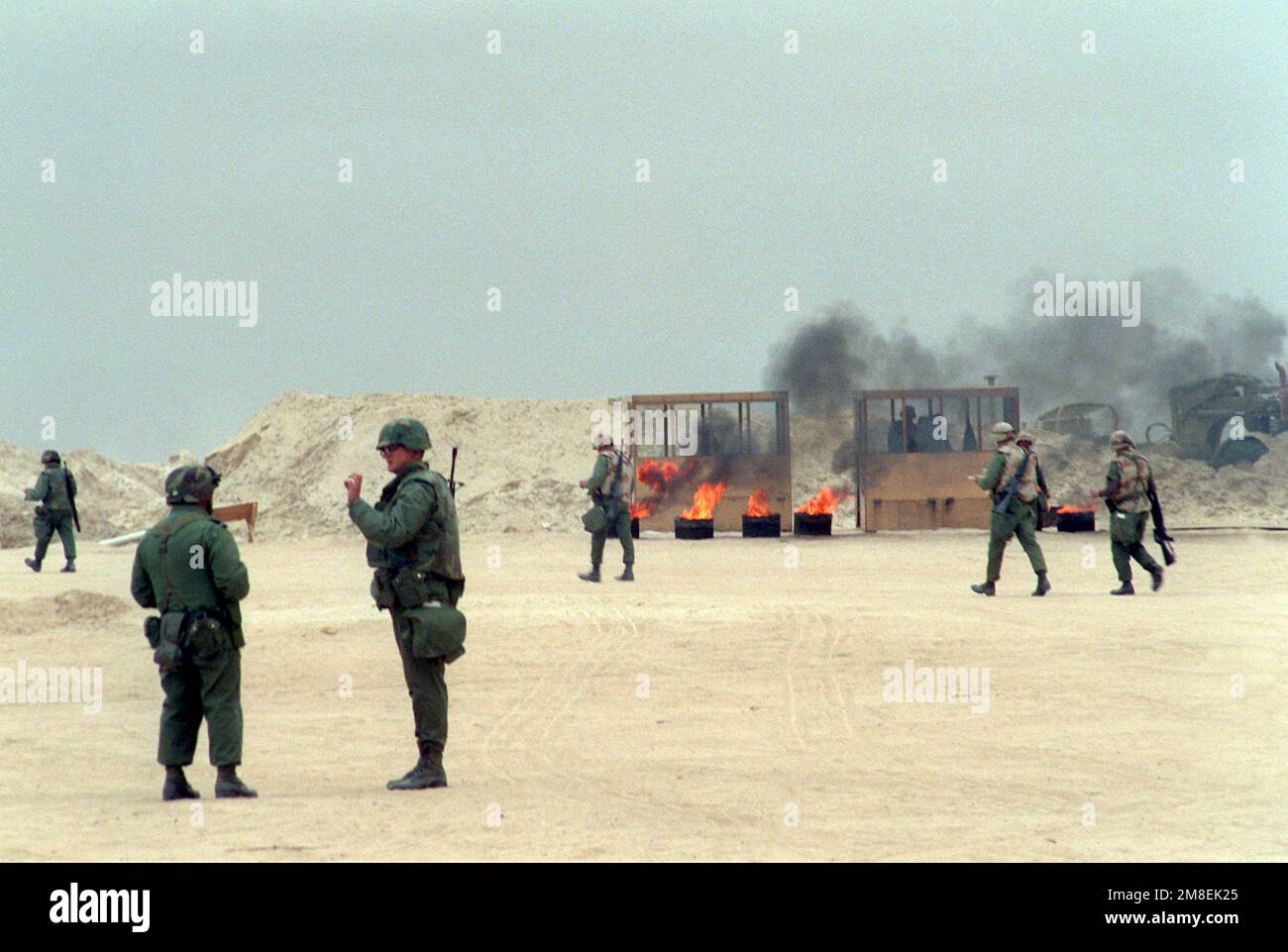 Waste cans taken from a latrine are burned at a forward camp being ...