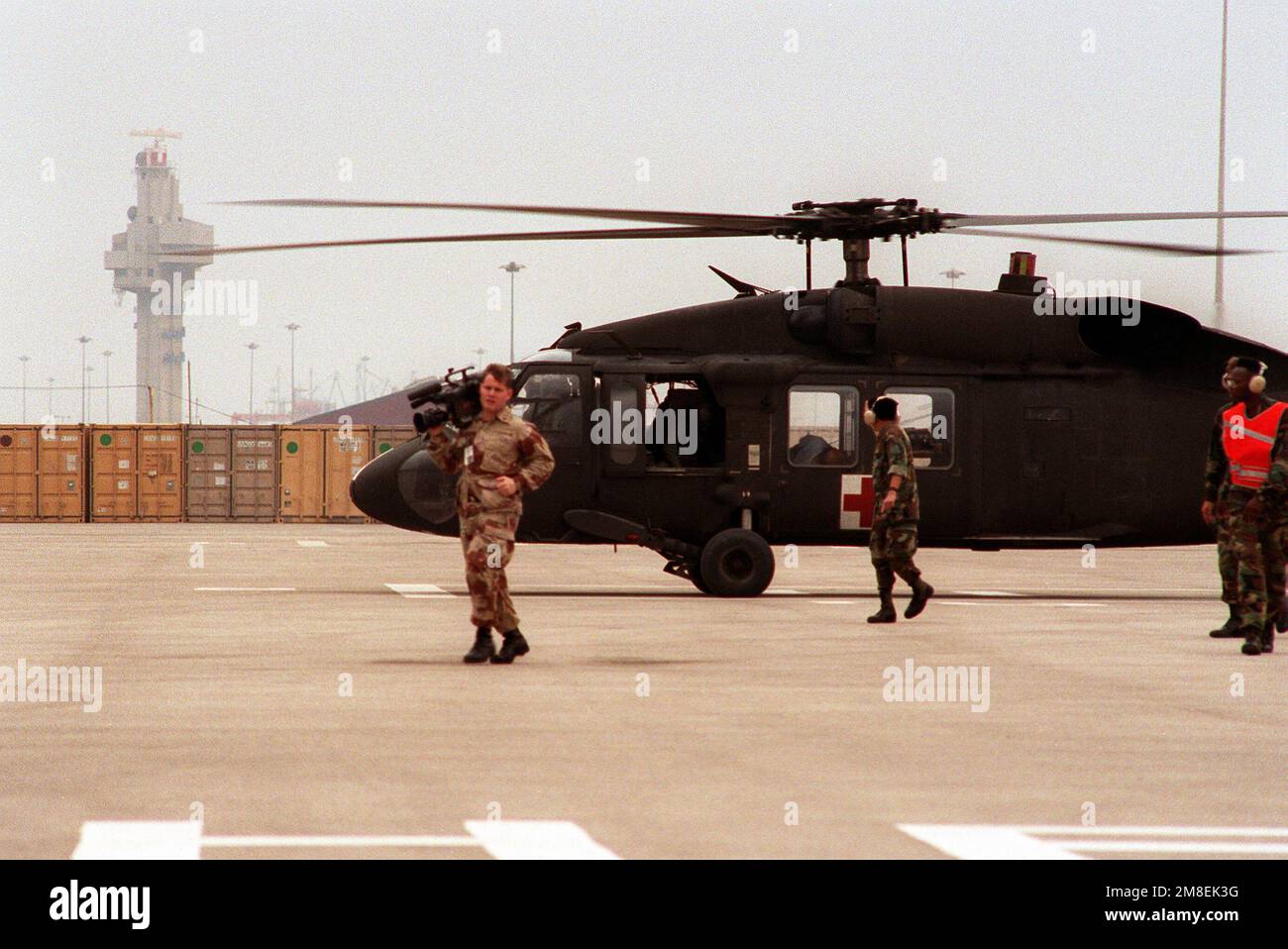 A Navy cameraman moves into position to videotape a wounded Marine being carried off an Army UH ...
