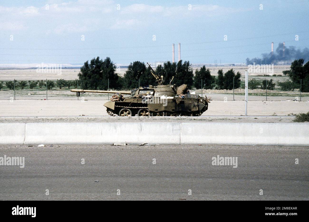 A damaged Iraqi T-55 main battle tank sits on a road after being ...