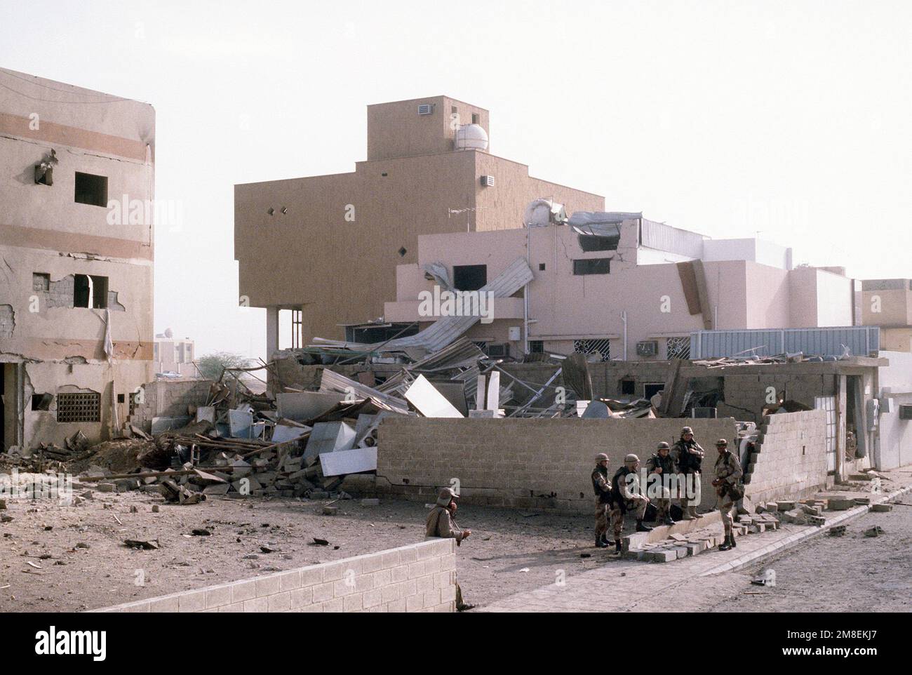 U.S. military personnel gather in a sector of a city damaged when an ...