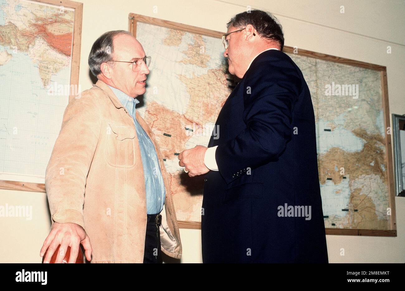 Secretary of Defense Richard Cheney speaks with an official during a ...