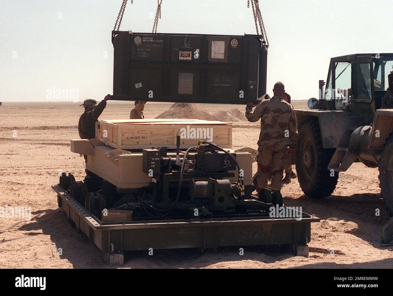 A crane is used to lift part of the shipping container off of a Mark ...