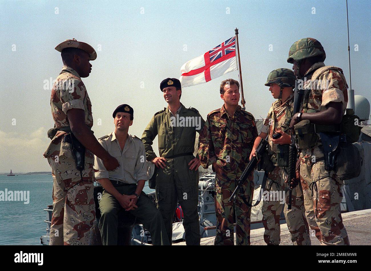 U.S. and British military personnel converse on the pier beside the ...