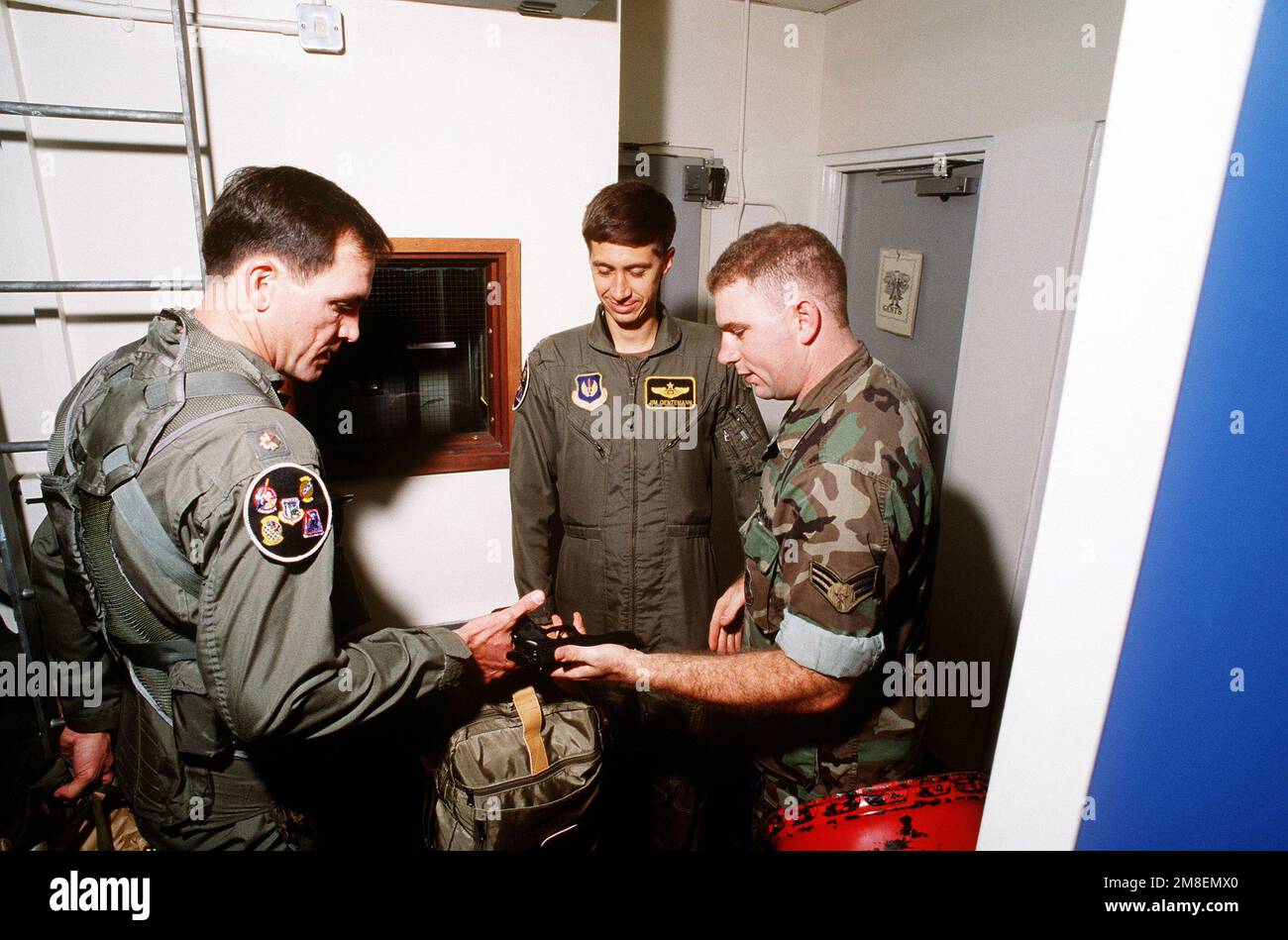 A 48th Tactical Fighter Wing air crewman receives an M-9 9mm pistol ...