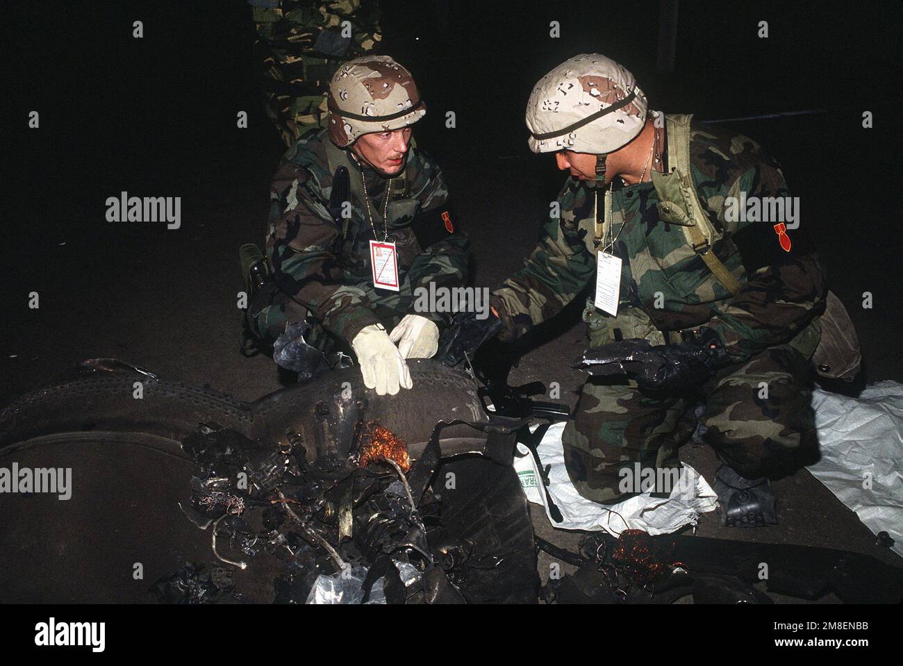 Explosive ordnance disposal technicians inspect the remains of an Iraqi ...