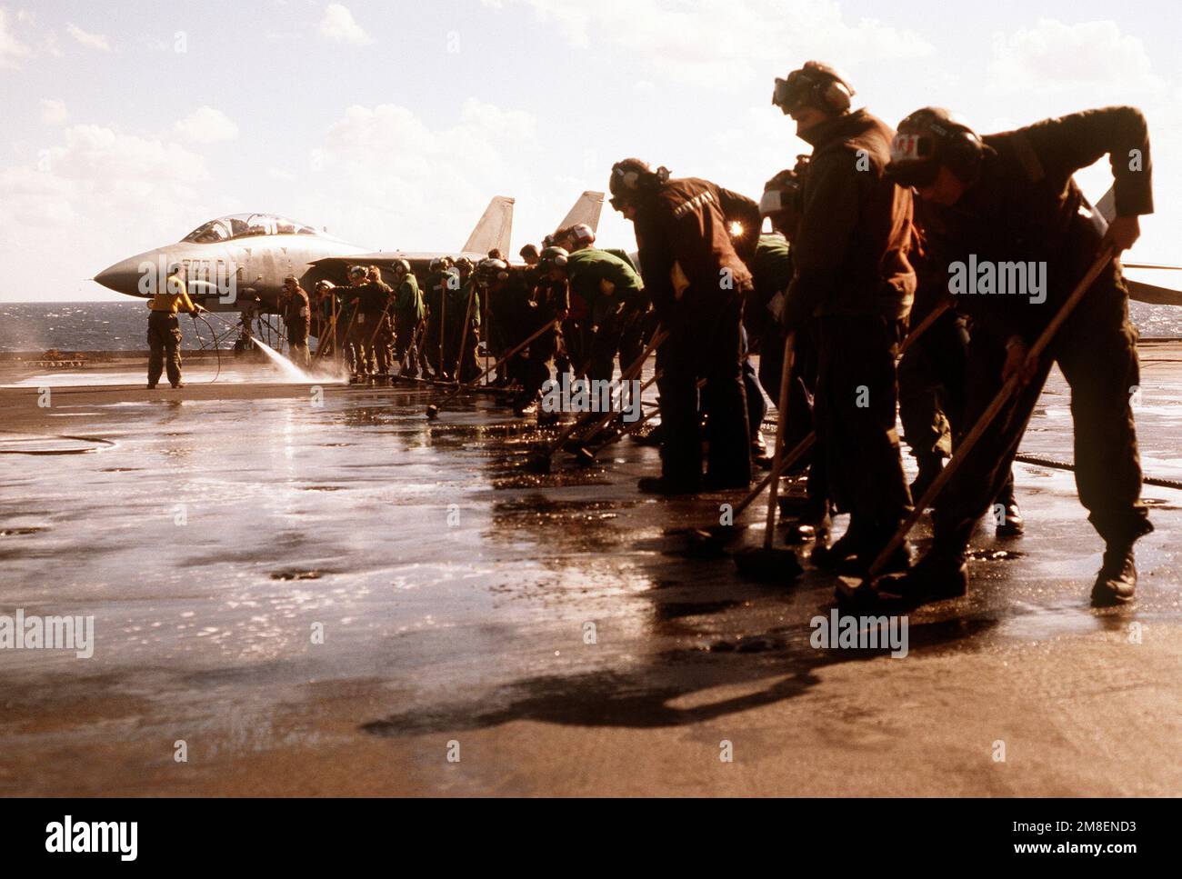 Sailors swab the flight deck of the aircraft carrier USS JOHN F ...